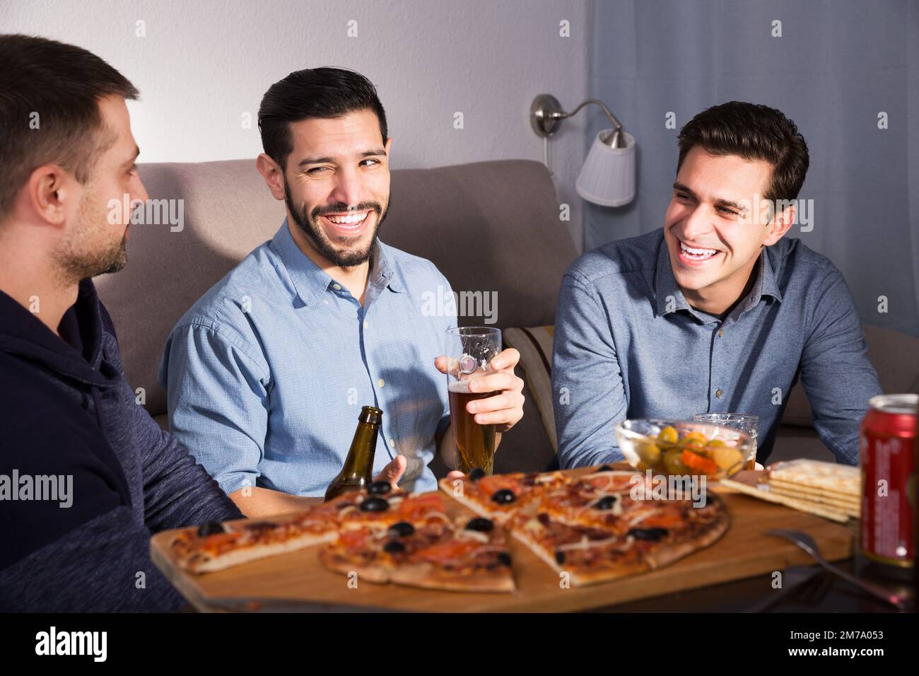 Three men talking and laughing at home Stock Photo - Alamy