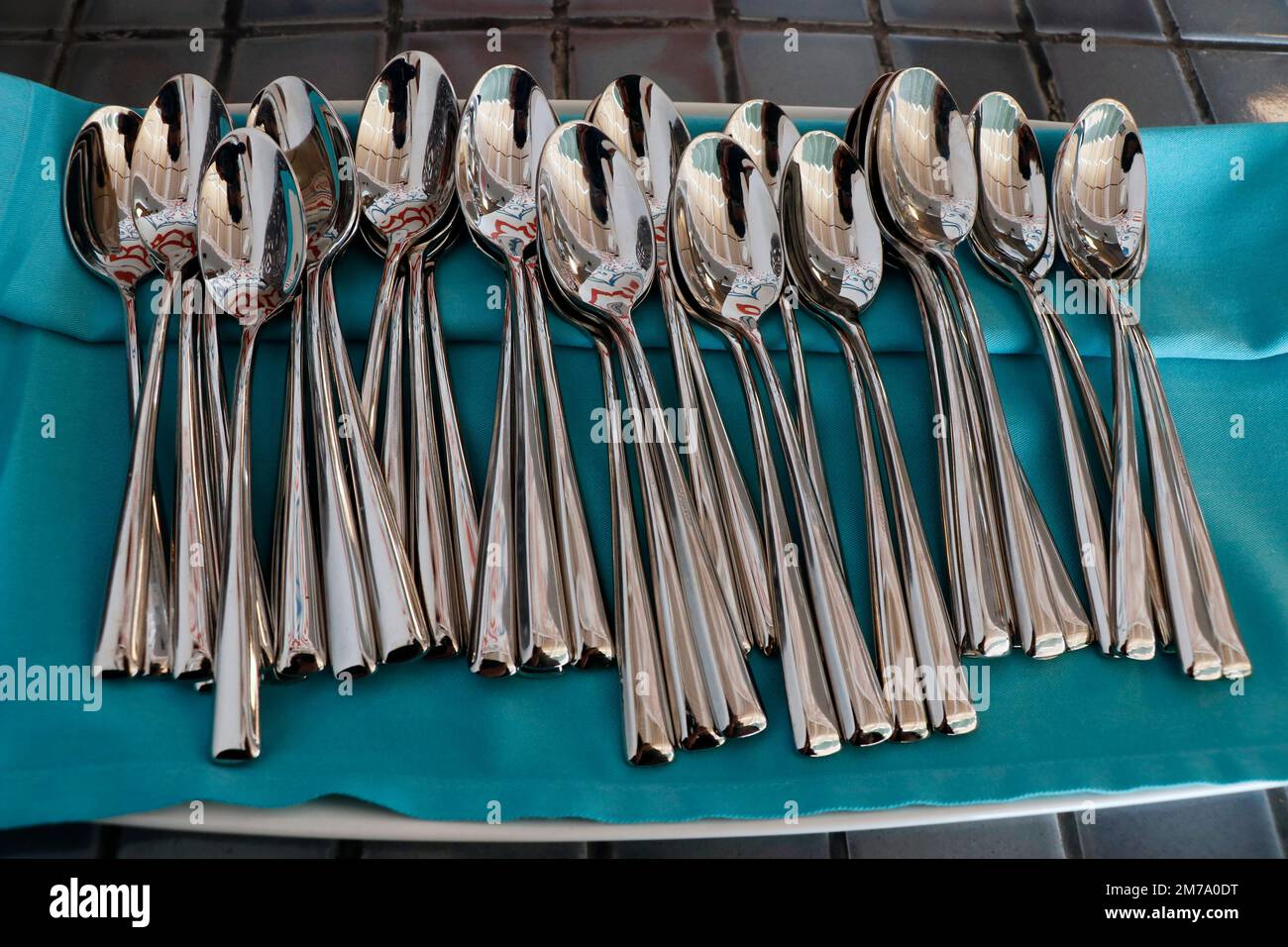 Group of steel metal spoons in tray with mat Stock Photo - Alamy