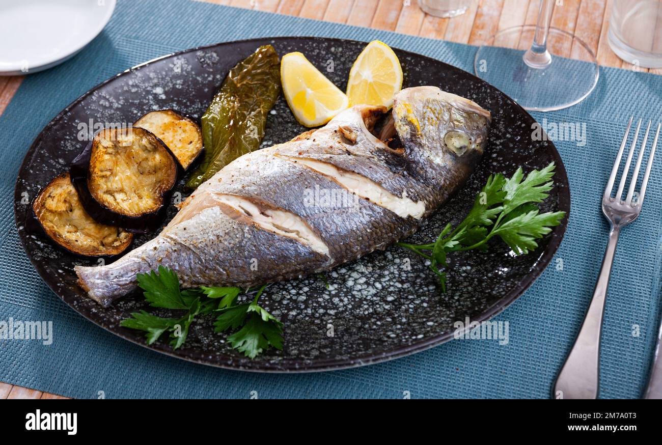 Dorada fish baked with lemon served with vegetable garnish Stock Photo ...
