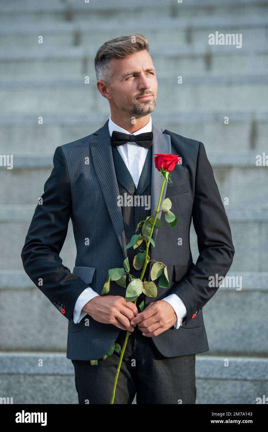 love rendezvous concept. caucasian tuxedo man with love rose. flower ...