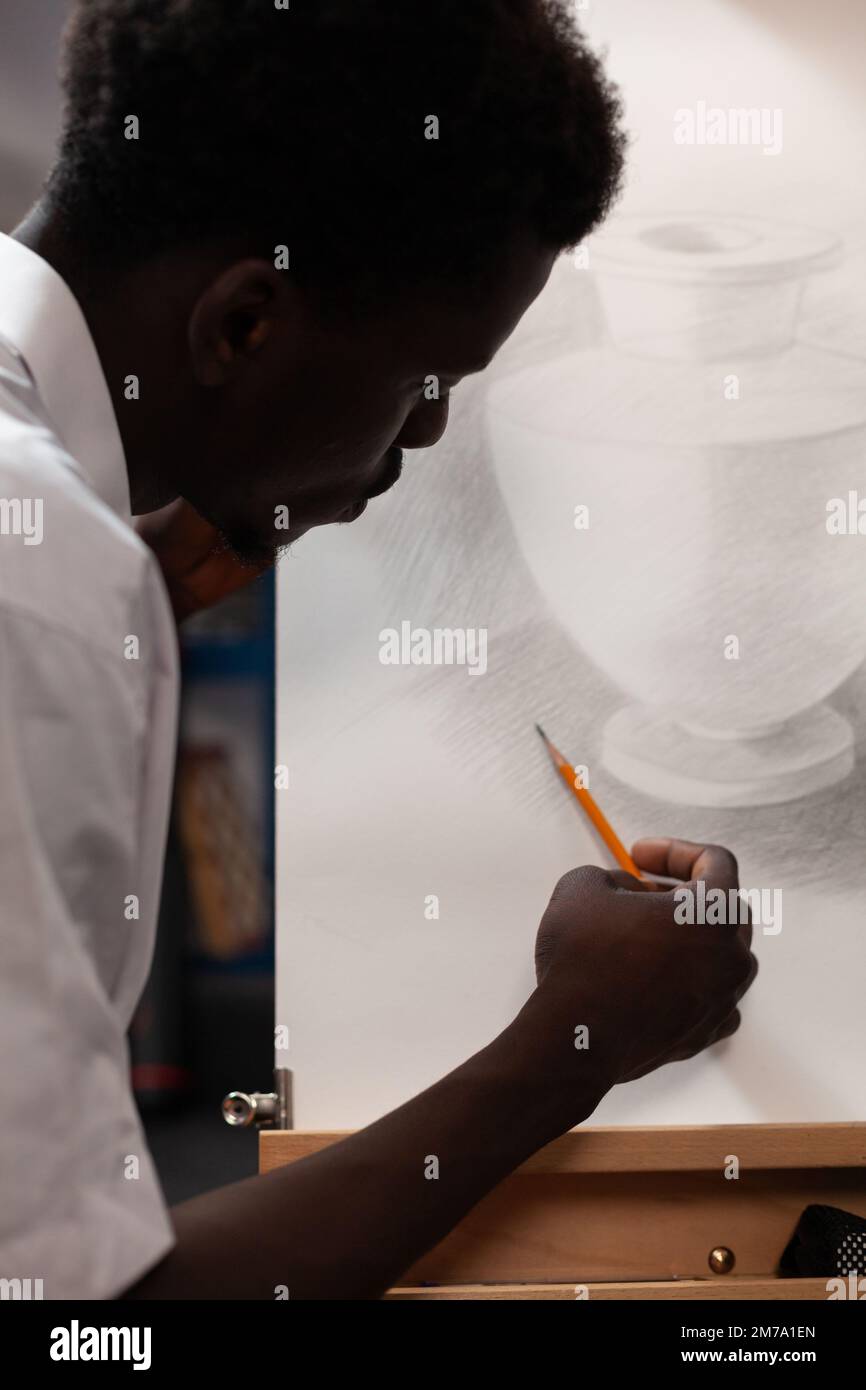 Close up shot of young male artist making hand drawn pencil sketch of ...