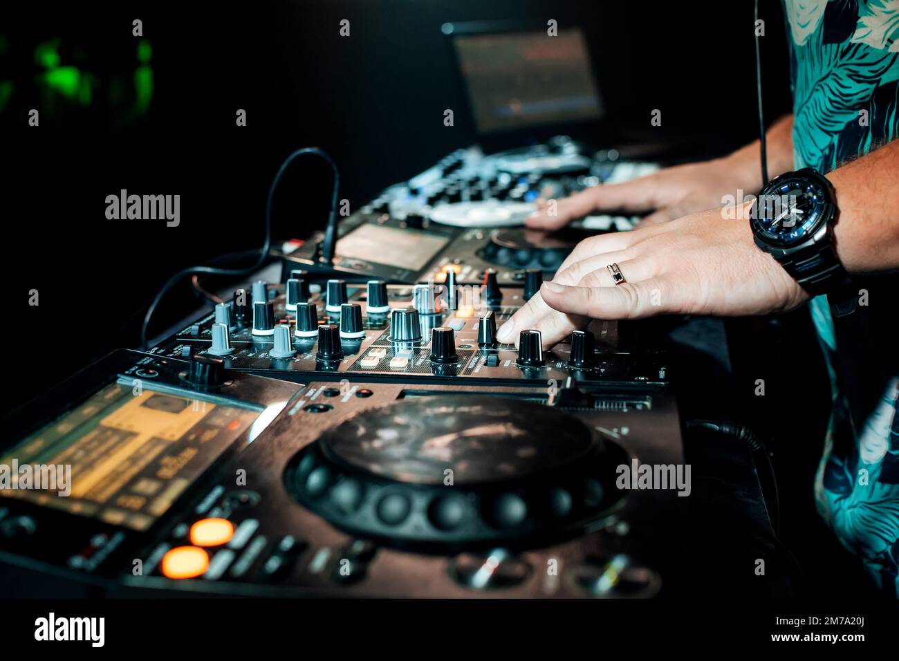 DJ hand mixes on a professional mixer controller at a concert of ...