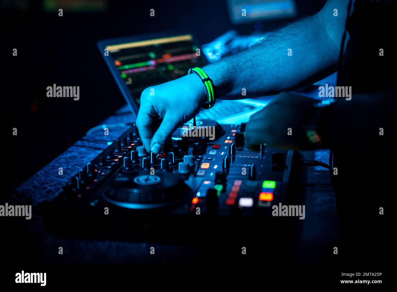 hand DJ mixing music on a professional controller Board in a nightclub ...