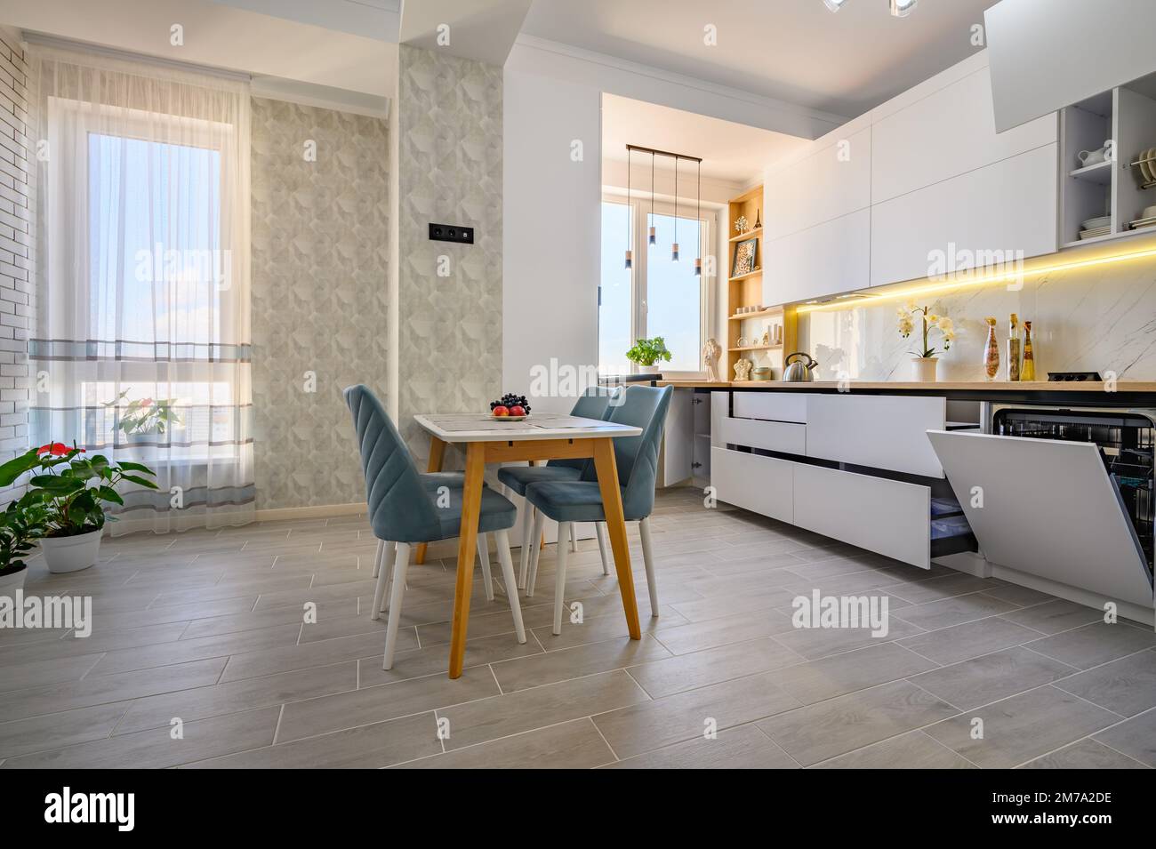 A simple white kitchen with drawers pulled out to their full length ...