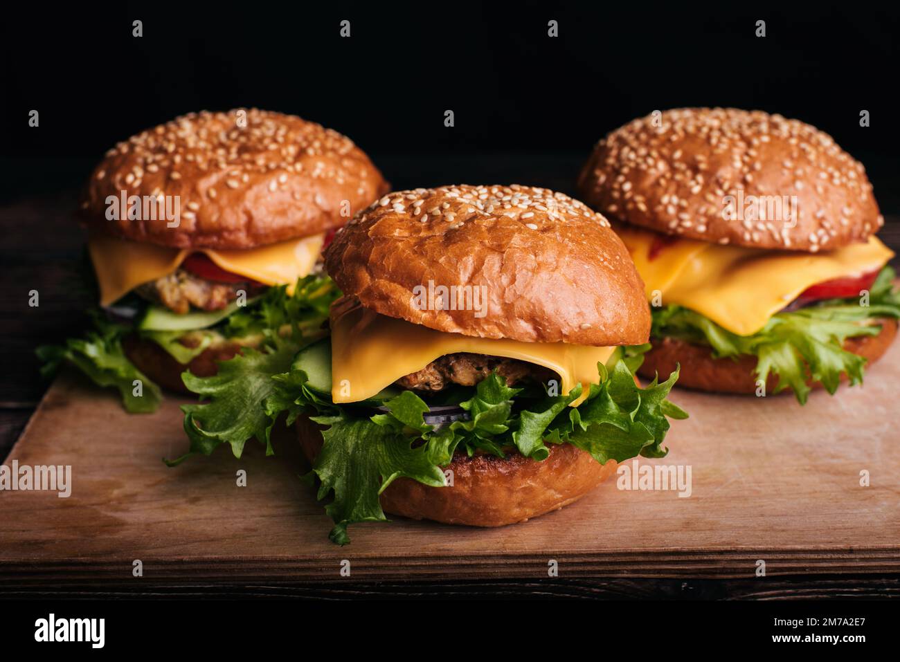 juicy homemade hamburgers with meat, cheese, lettuce, tomato on a Board ...