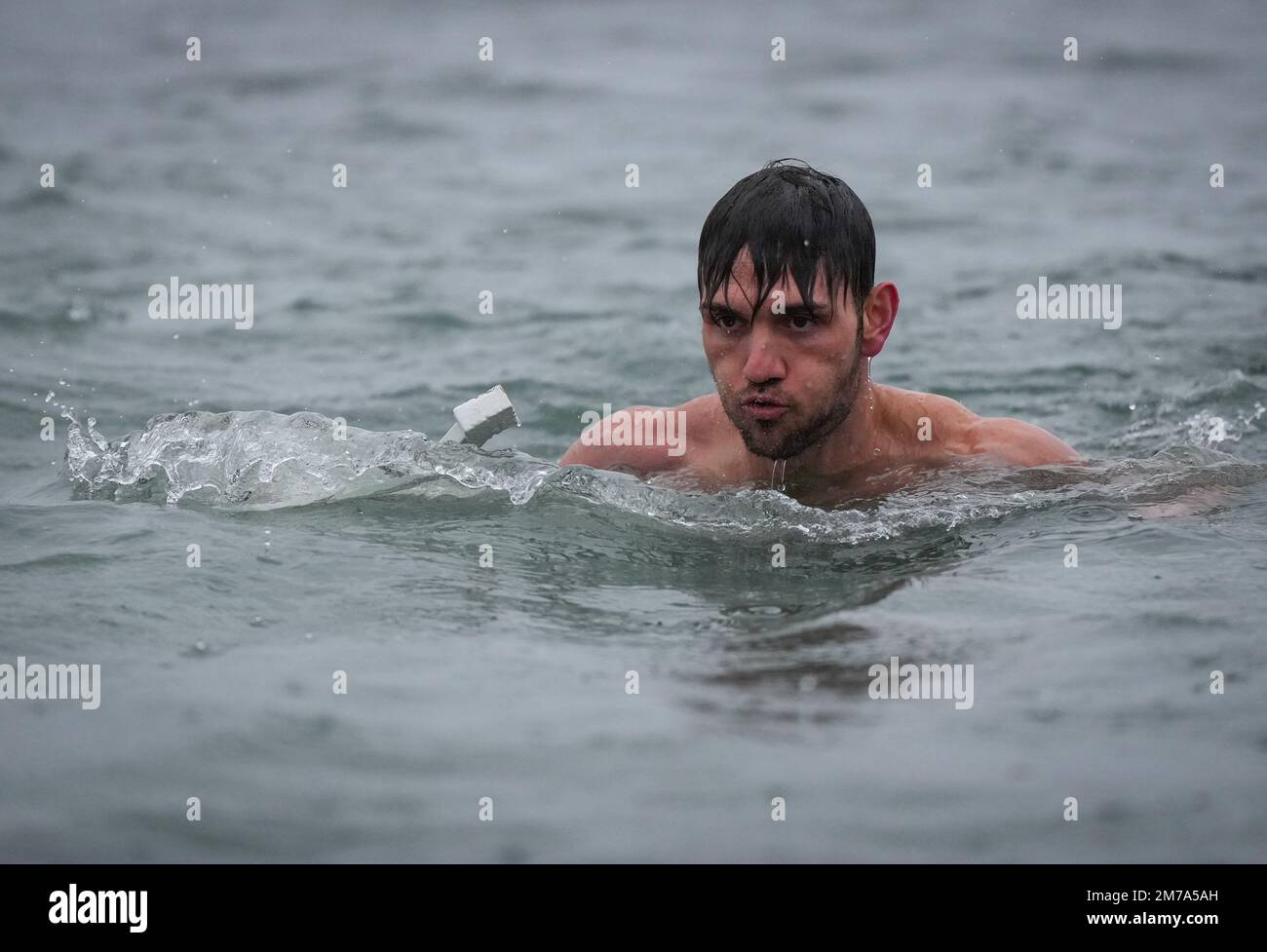 Mike Fraser swims back with the cross after going into English Bay to ...