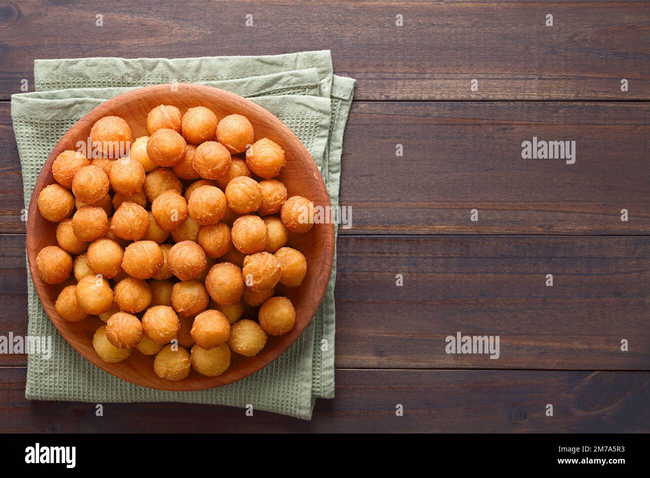 Fresh round baked Duchess potatoes or croquettes on wooden plate ...