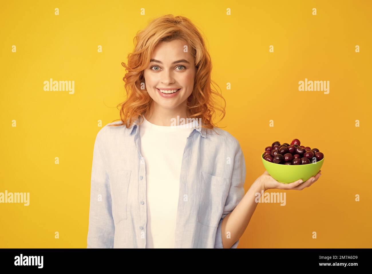 Attractive young woman eating fresh cherry. Healthy summer fruits ...