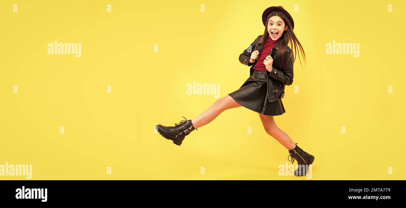 happy teen girl in hat and leather clothes making wide step forward ...