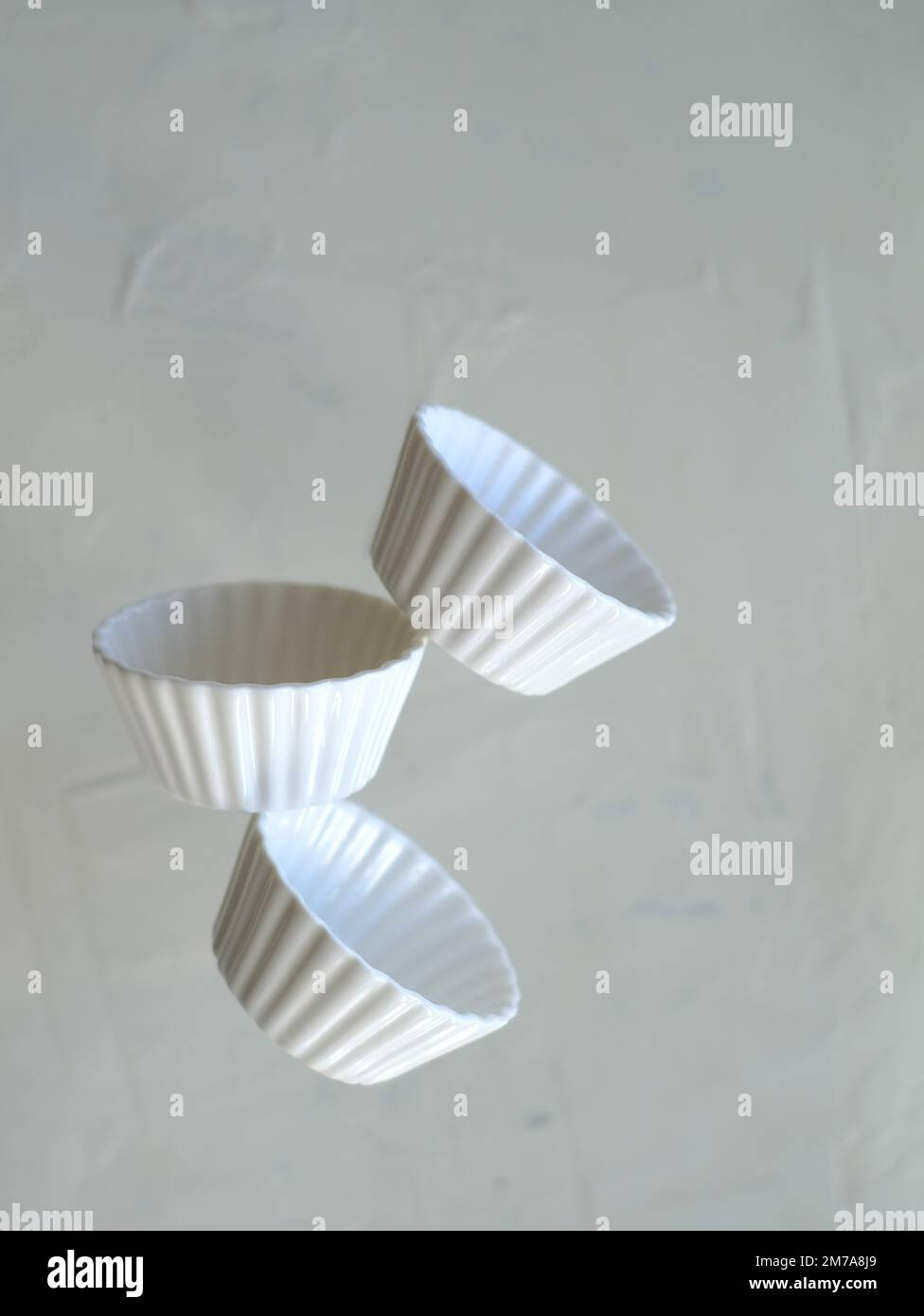 Flying white bowls in levitation on air Stock Photo - Alamy