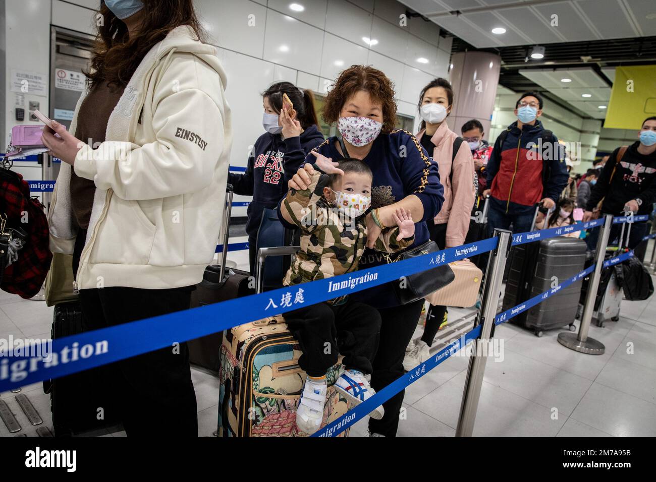 A mother with her son seen queuing up in the queue at the border ...