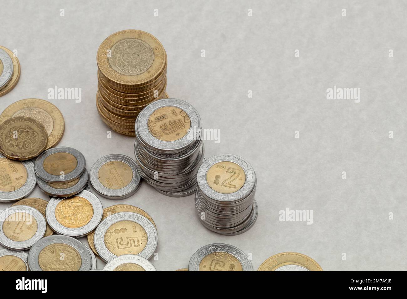 stack of mexican peso coins of various denominations, with copy space ...