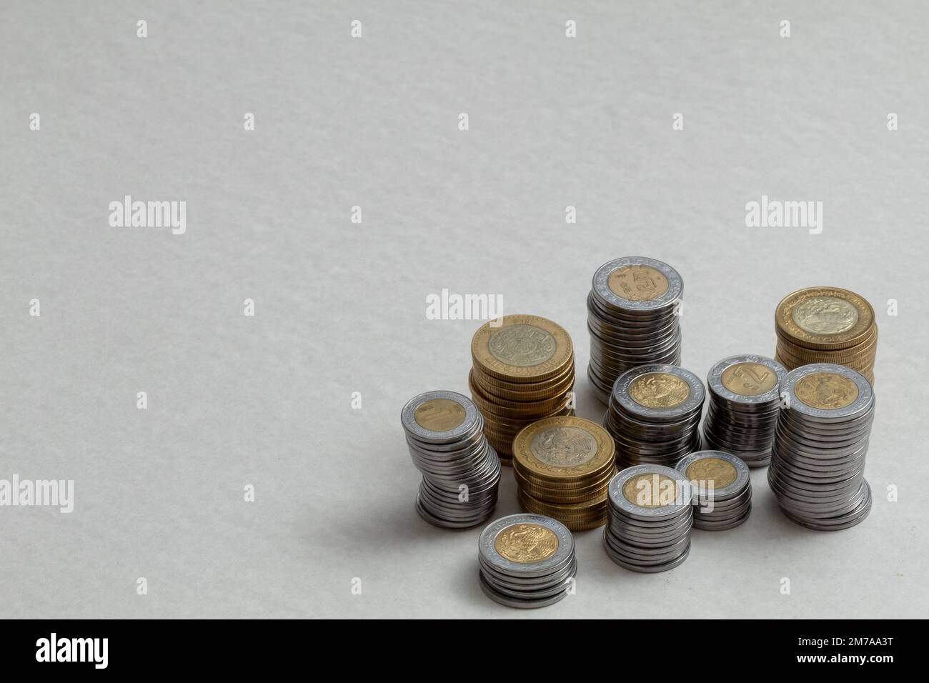 Group of coins stacked on the corner of a table, with copy space ...