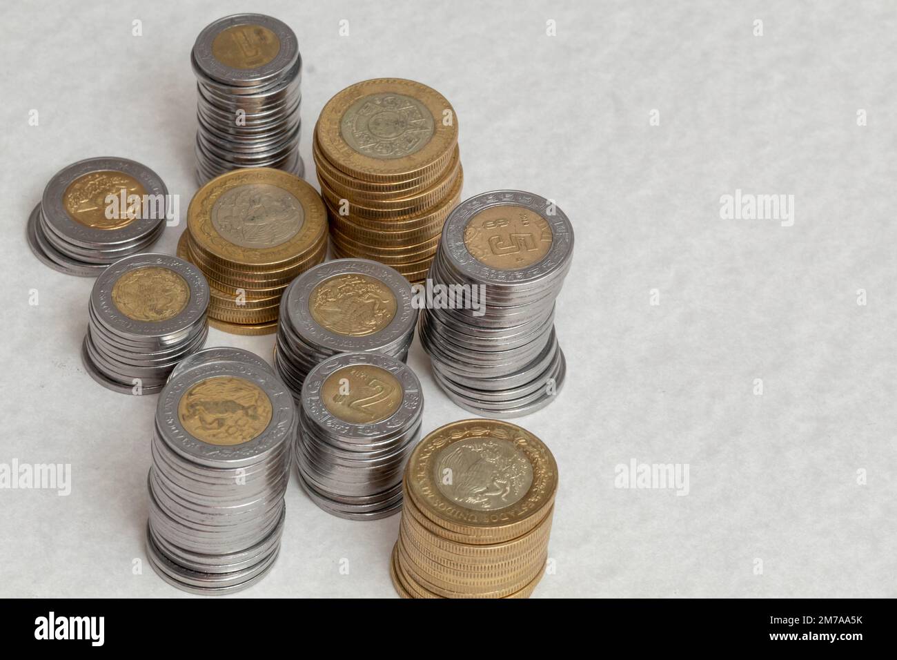 Group of coins stacked on the corner of a table, with copy space ...