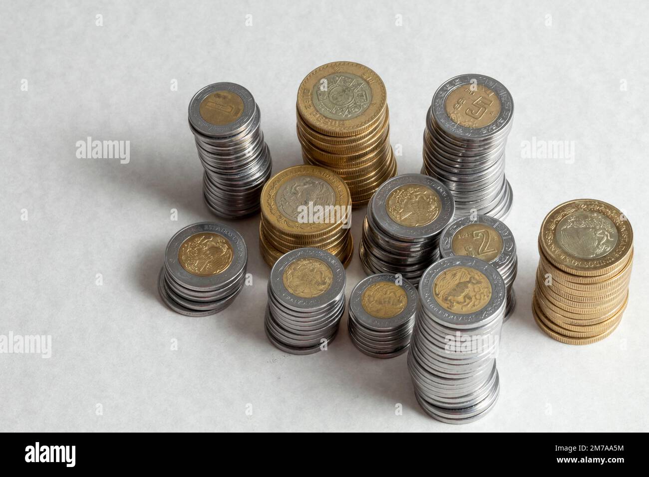 Group of coins stacked on the corner of a table, with copy space ...