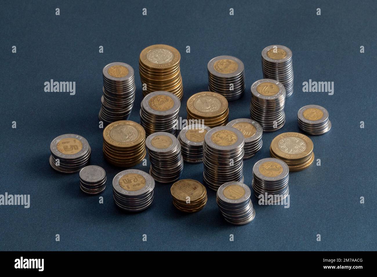 Piles of Mexican pesos coins, of different denominations isolated with ...