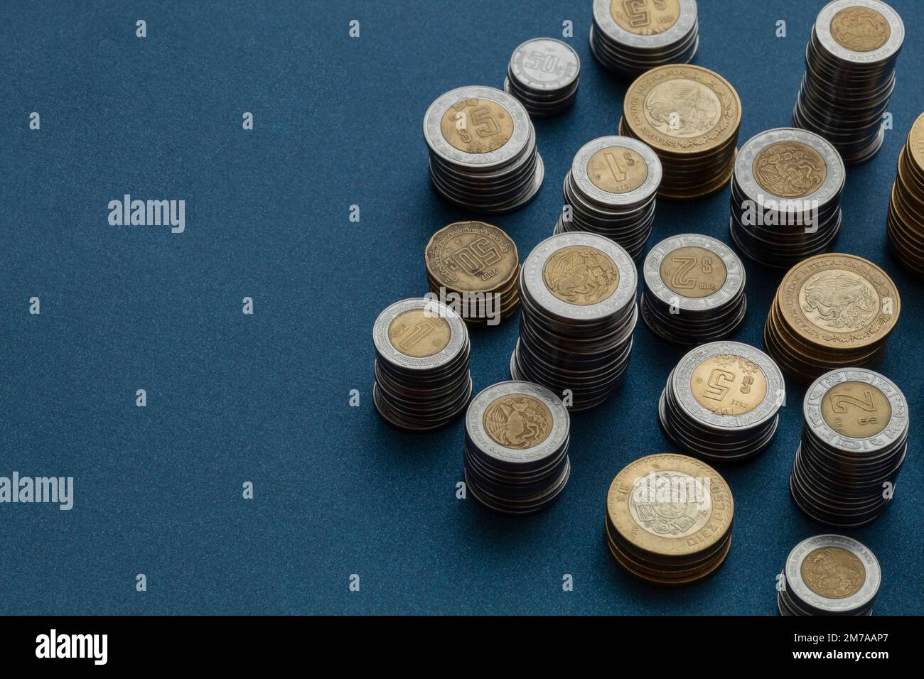 Piles of Mexican pesos coins arranged in the corner of the image with ...