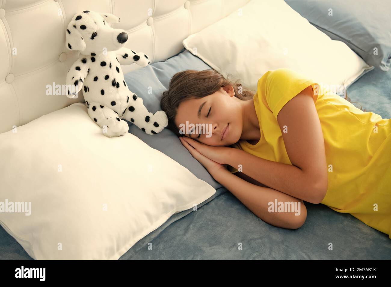 Kid lying and sleeping on bed with toy. Child teen sleeps in the bed ...
