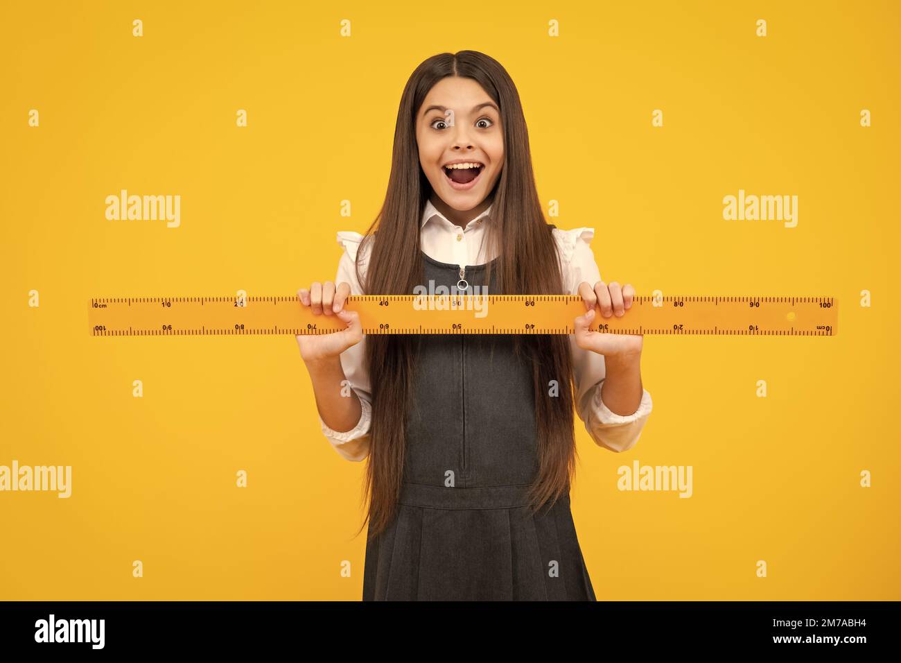 Schoolgirl in school uniform hold mathematics measure. Metric ...