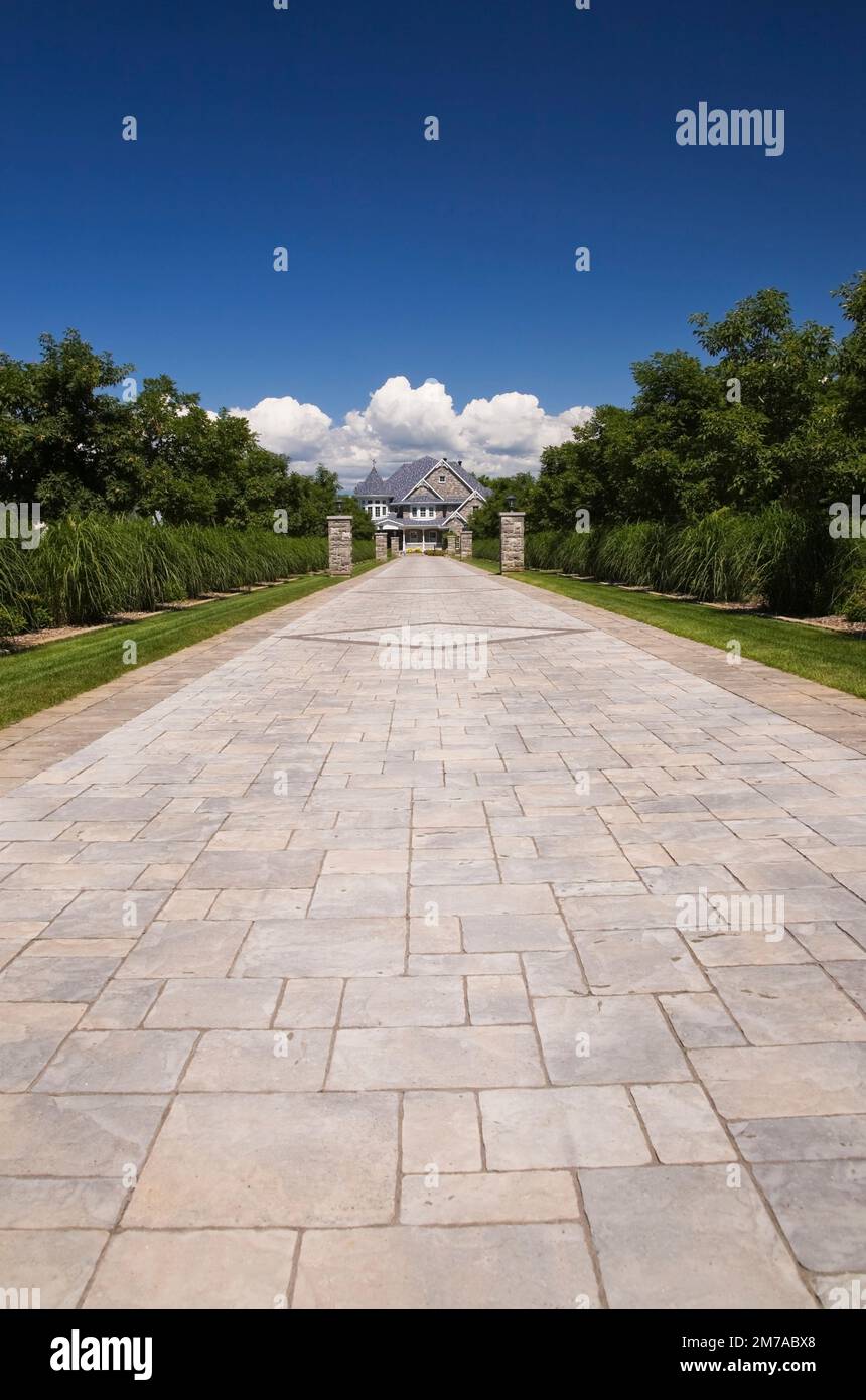 Paving stone alley with stone columns bordered by Miscanthus ...