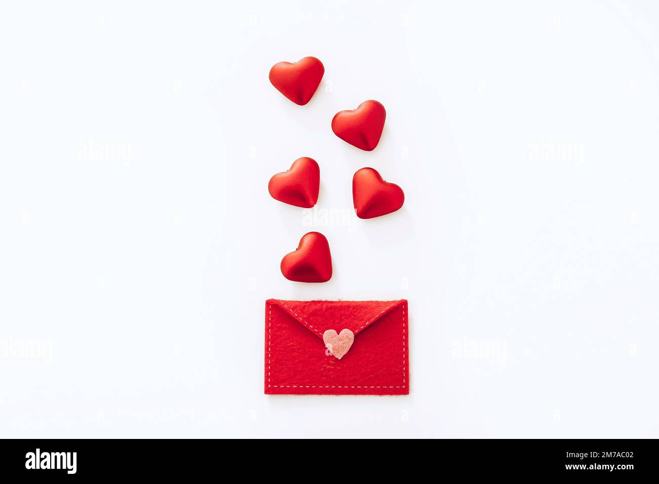 Red felt envelope with hearts on white background Stock Photo - Alamy