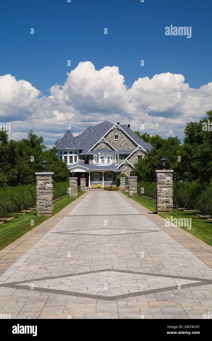Paving stone alley with stone columns bordered by Miscanthus ...