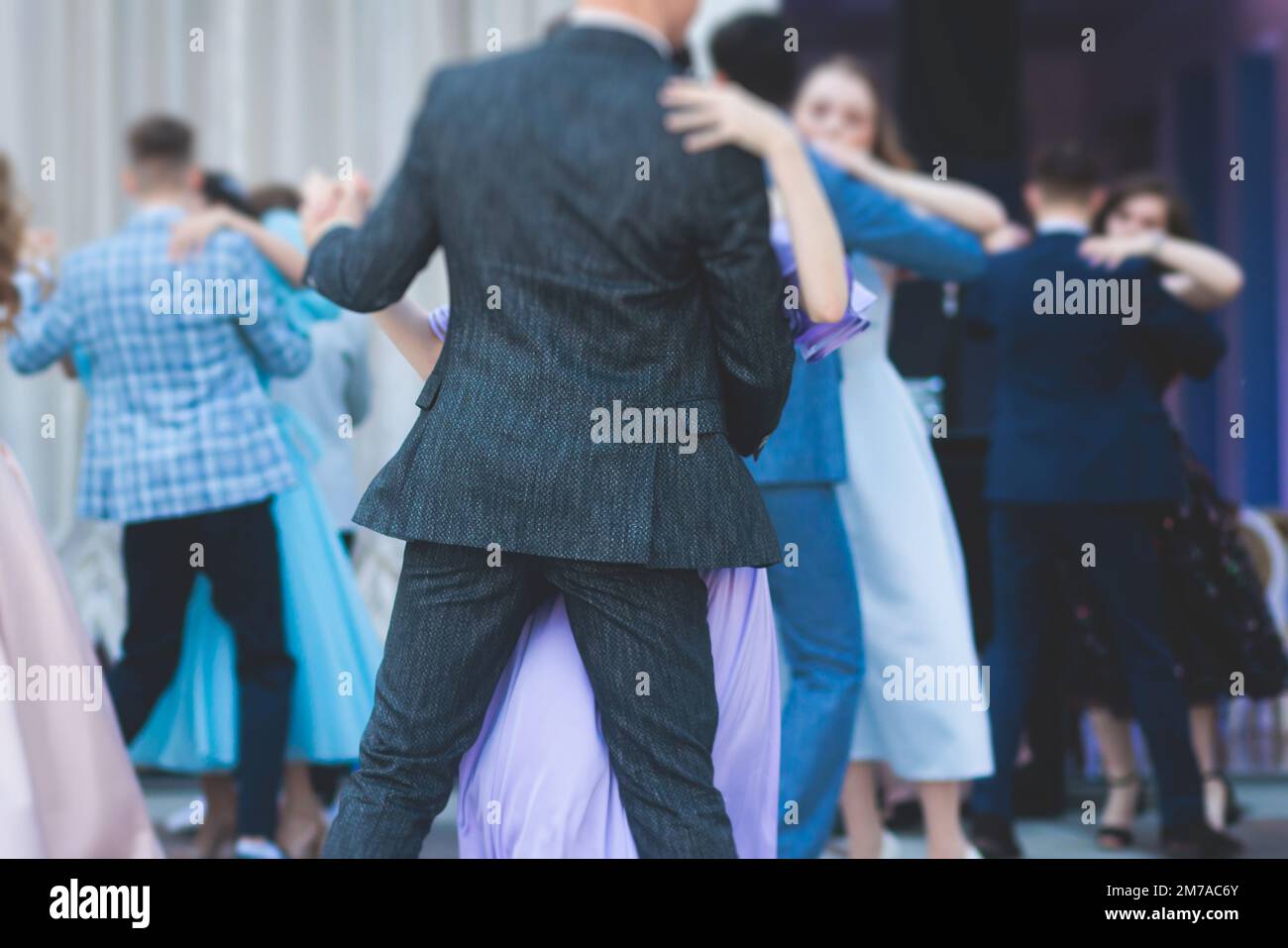 High school graduates dancing waltz and classical ball dance in dresses ...