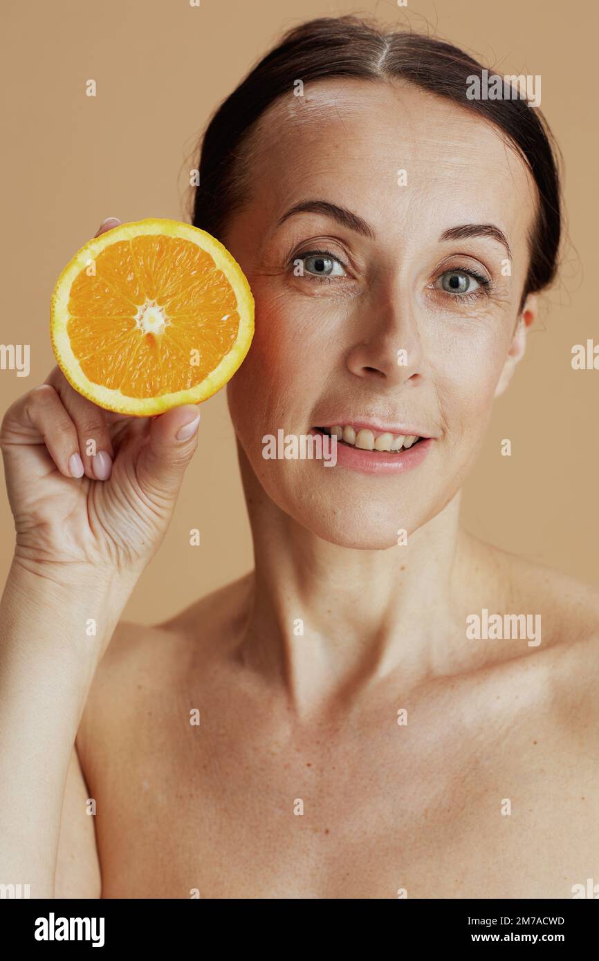 Portrait Of Happy Modern 40 Years Old Woman With Orange Isolated On