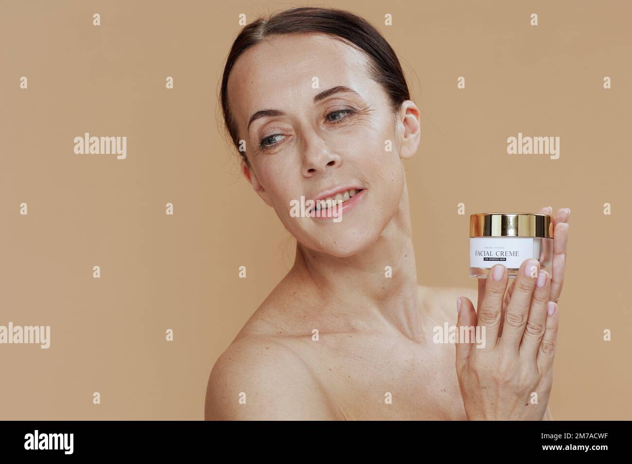 Portrait Of Modern 40 Years Old Woman With Facial Cream Jar Against