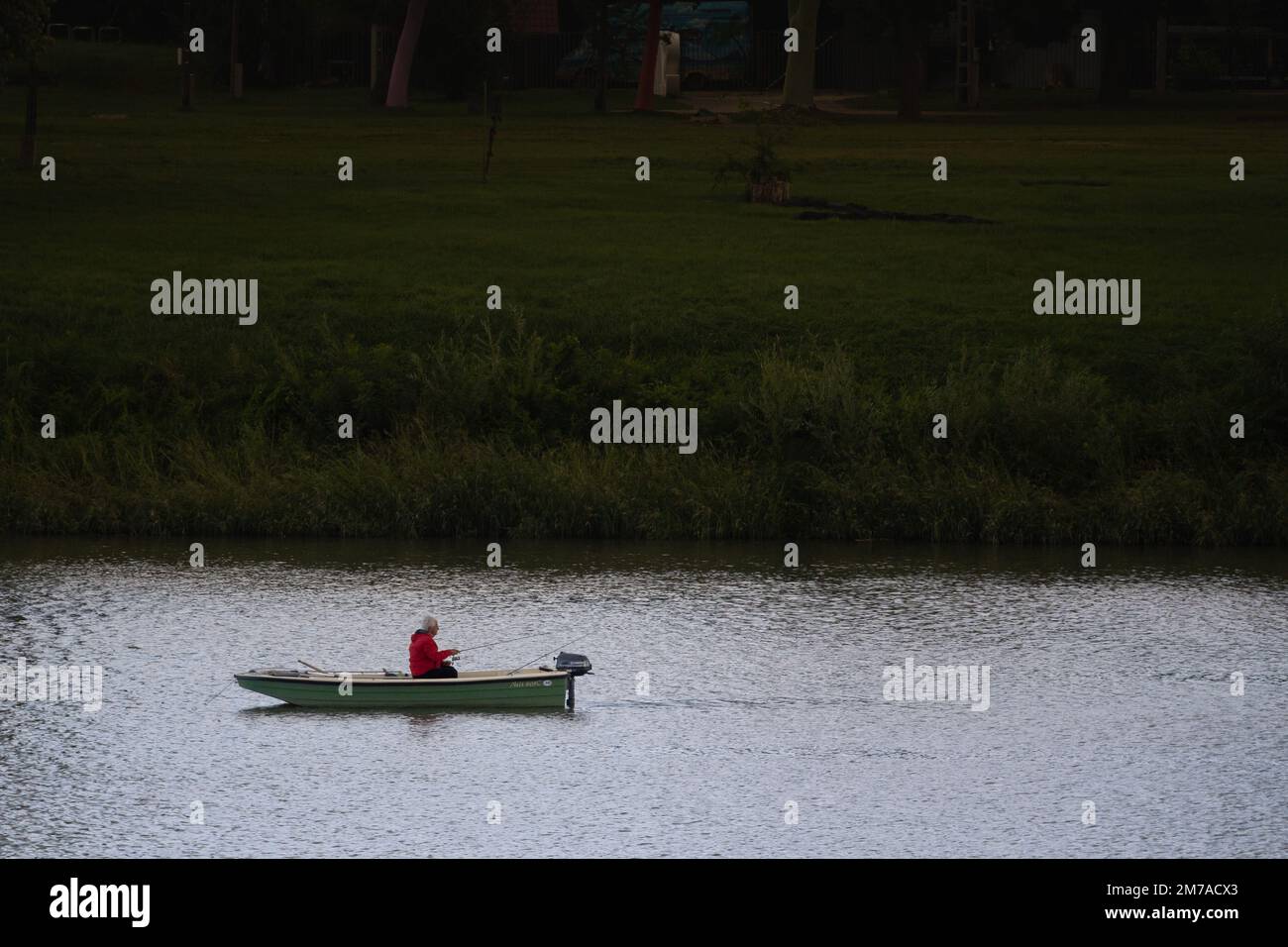 Picture of a fisherman enjoying and relaxing, fishing on Tisza river in ...