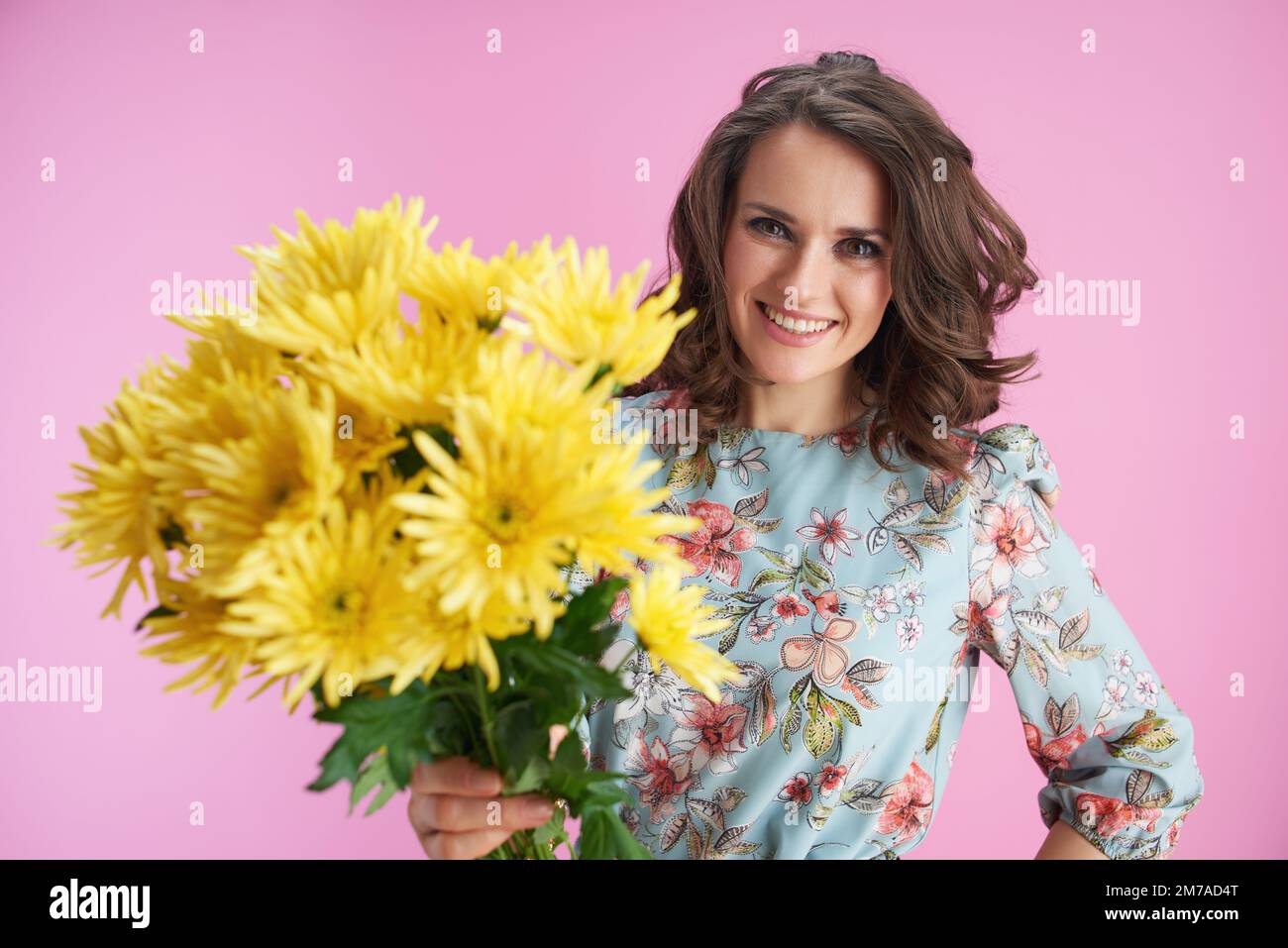 smiling young female with long wavy brunette hair with yellow ...