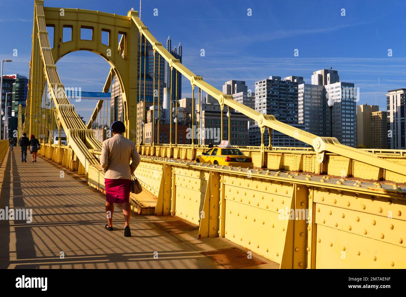 An adult woman walks to work across the Roberto Clemente Bridge in ...
