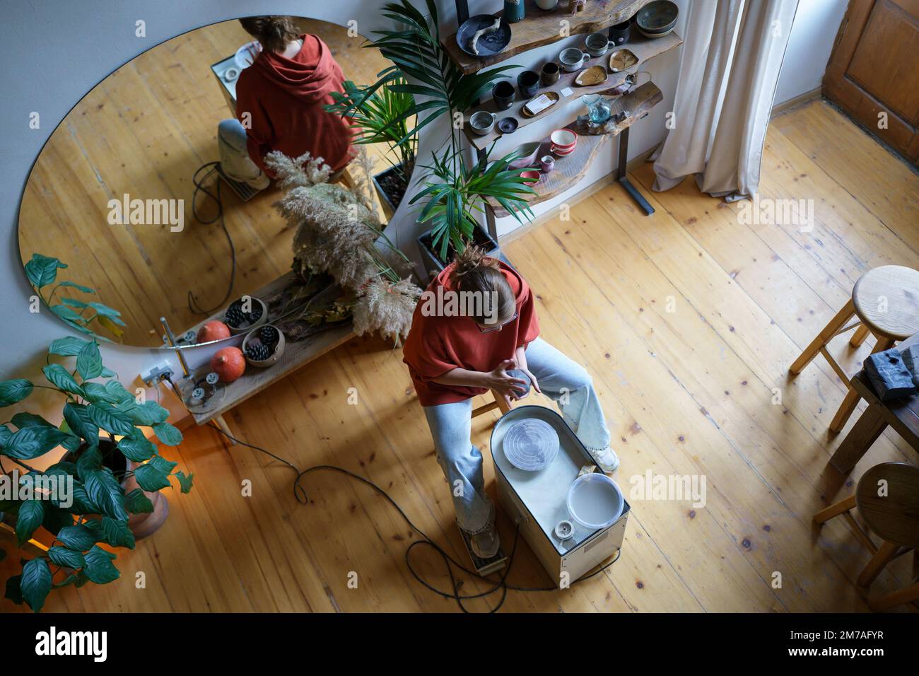 Potter working at cozy ceramics workshop, woman ceramist using pottery ...