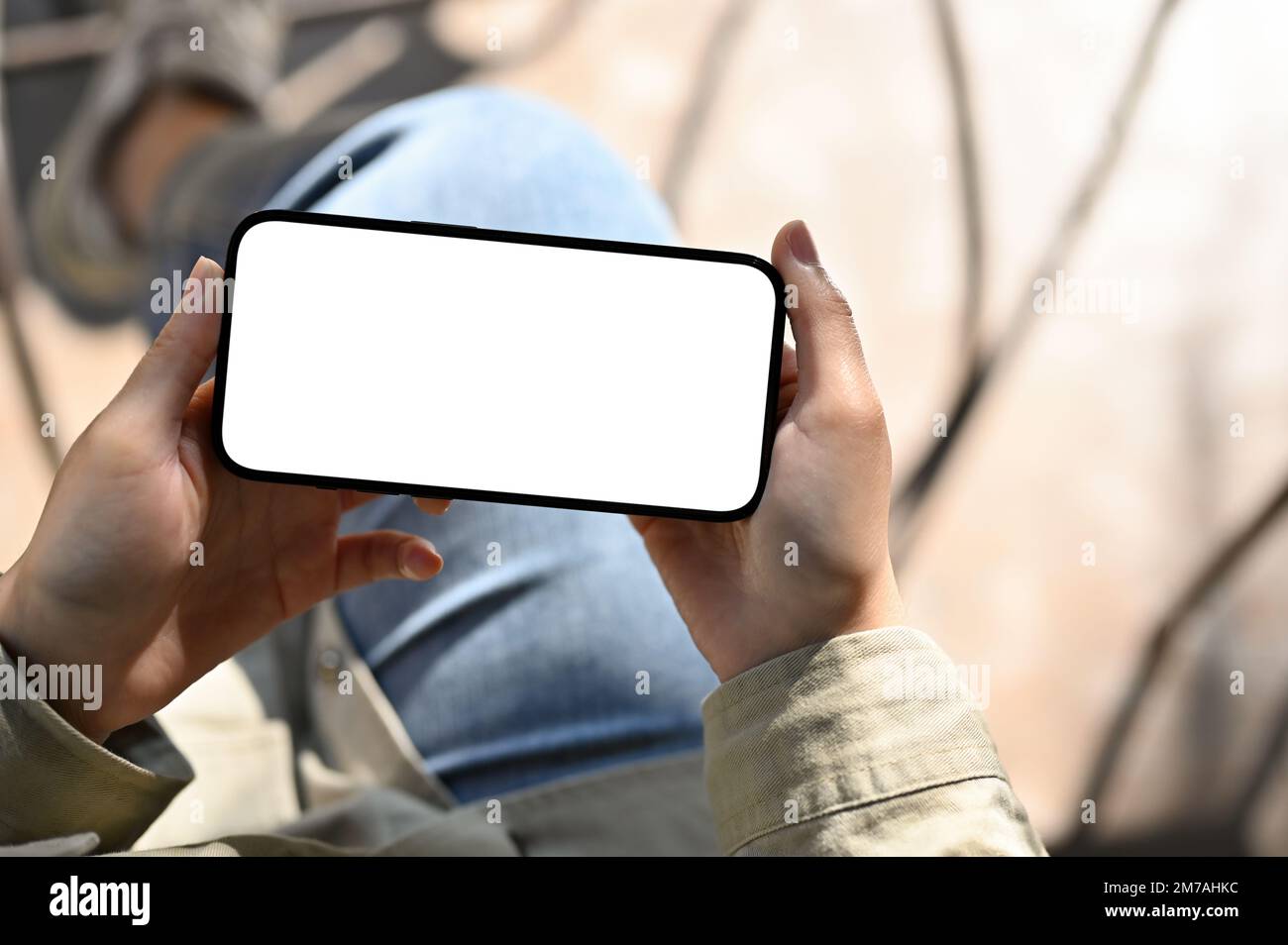 Above view, A female holding a smartphone in horizontal position ...