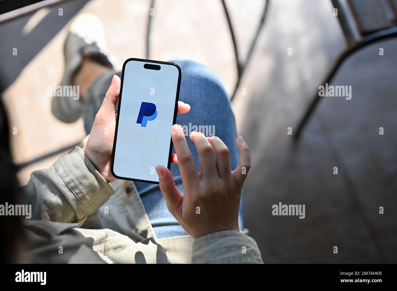 Chiang Mai, Thailand - Dec 27 2022: An Asian woman using PayPal application through her ...
