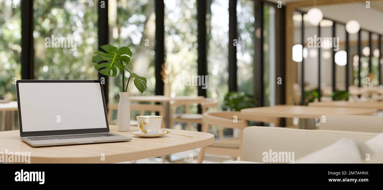 Portable laptop white screen mockup, a cup of coffee and flower vase on ...