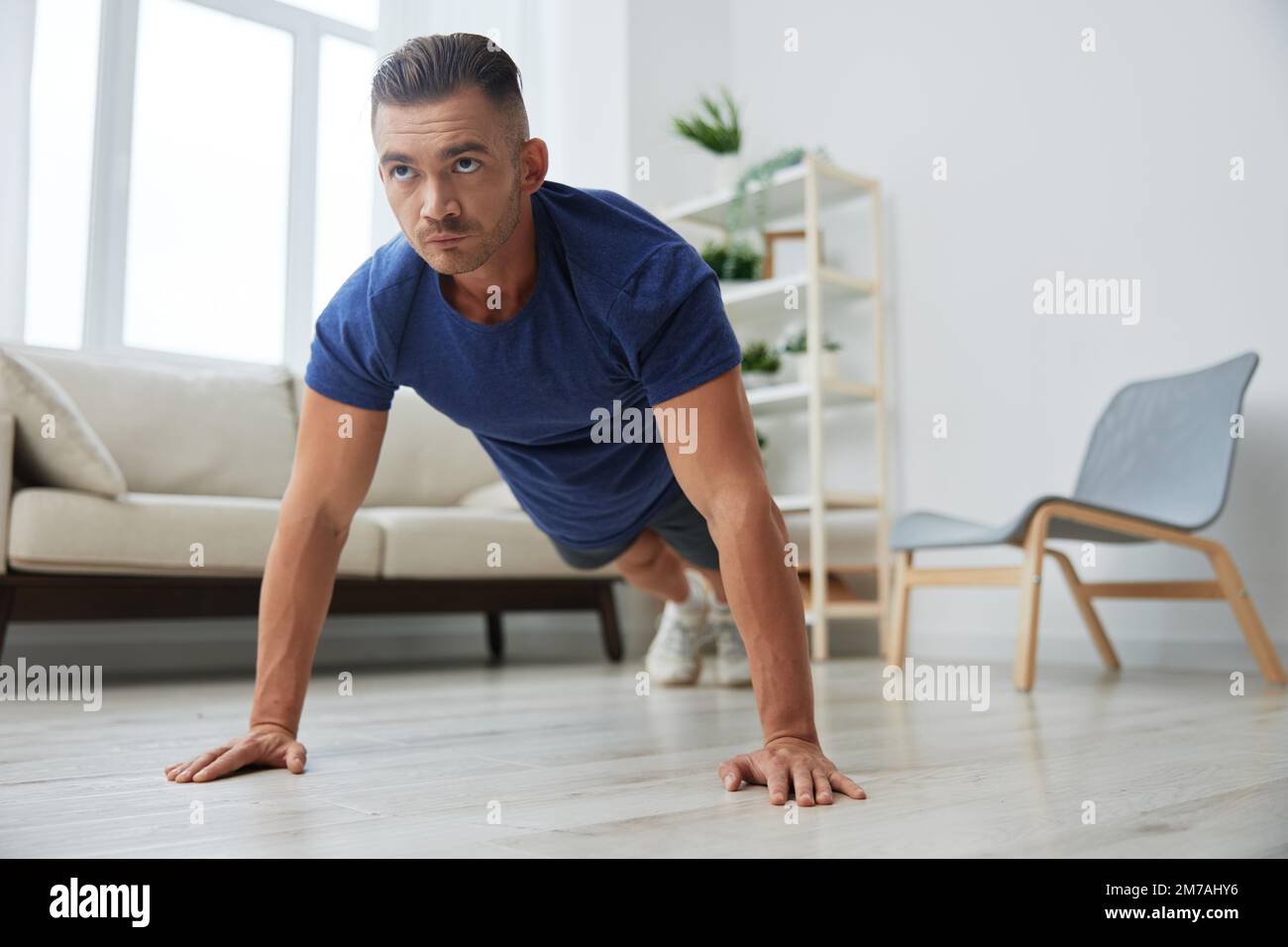 Man sportsman training at home, push-up exercises for arm, leg and back ...