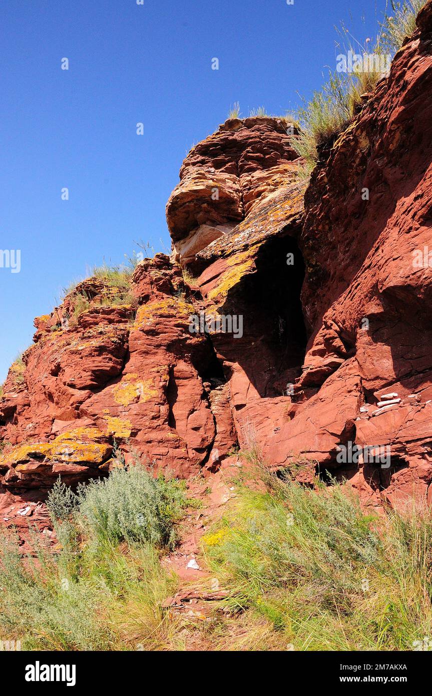 A narrow path runs along an ancient stone wall of red stratified ...