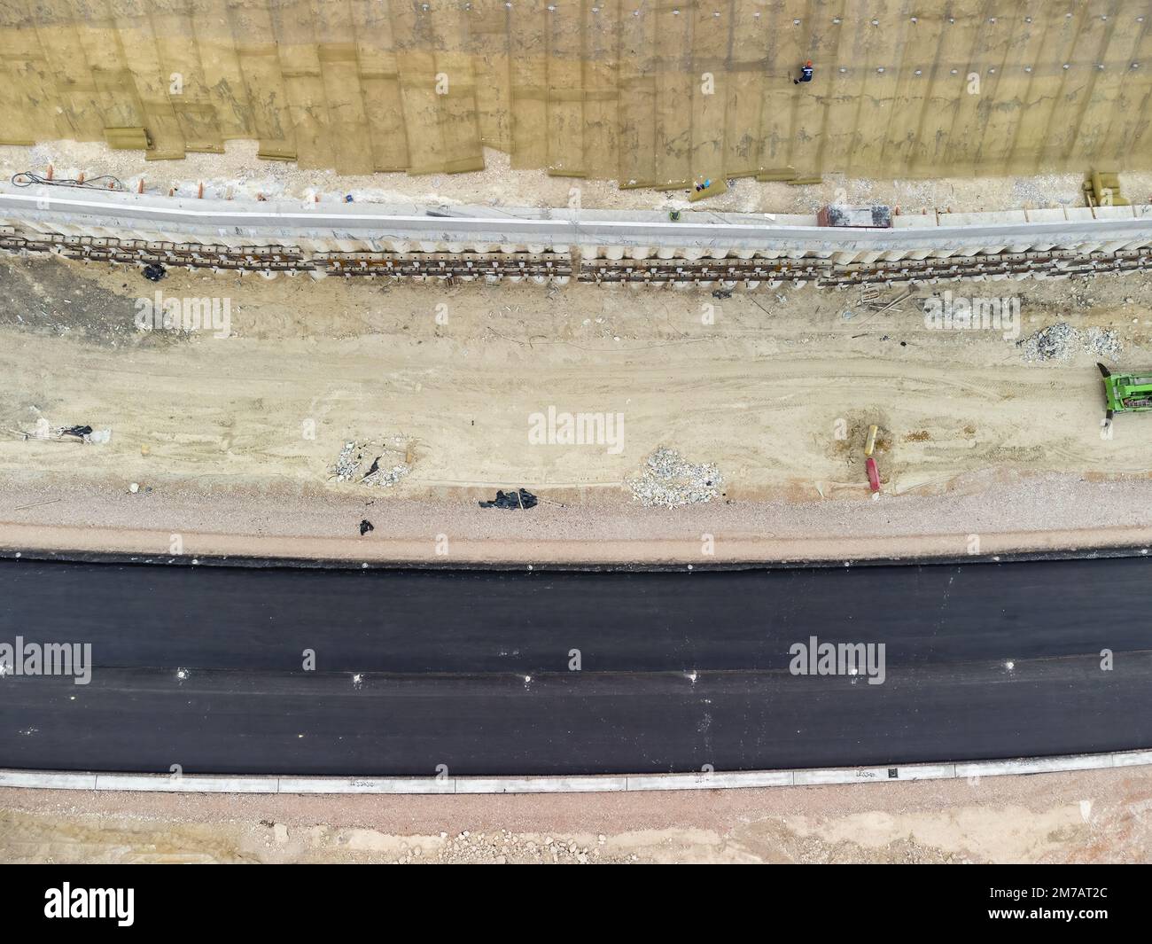 Mountain road constraction. Workers reinforce the slope over the new ...