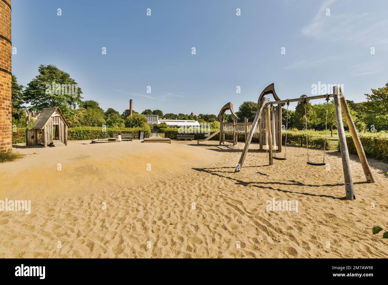 an empty playground with sand and trees in the background on a clear ...
