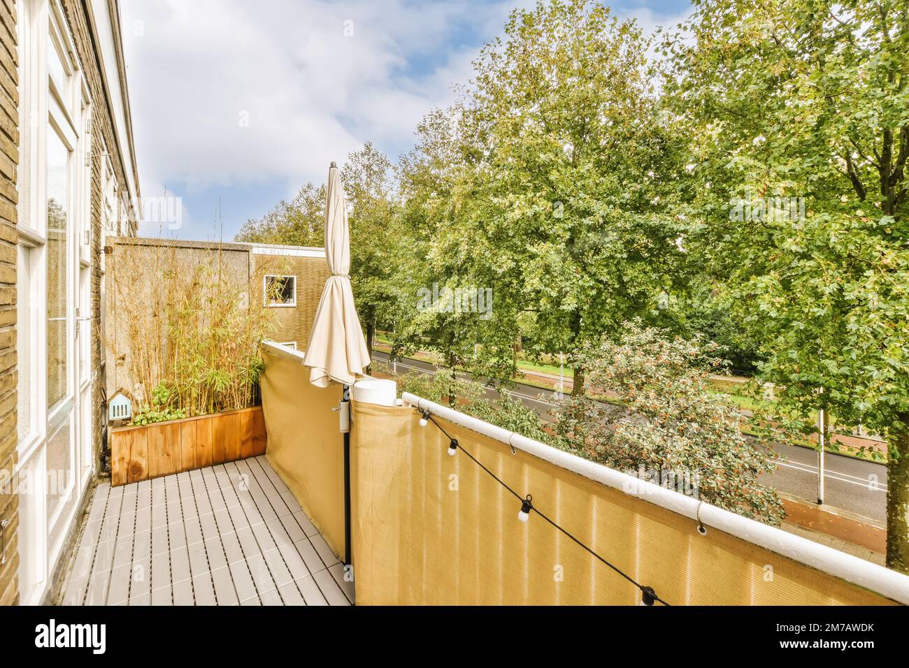 a balcony with wooden decking and plants on the wall, blue sky in the ...