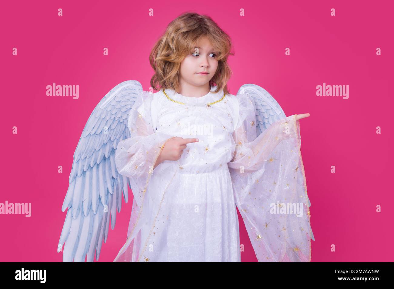 Child angel pointing finger, point gesture. Cute angel child, studio ...
