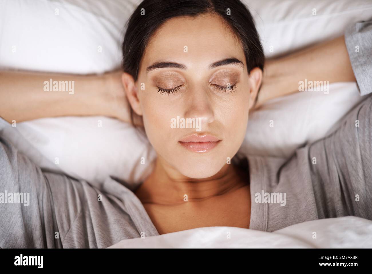 Catching up on her beauty sleep. an attractive young woman asleep in her bed Stock Photo - Alamy