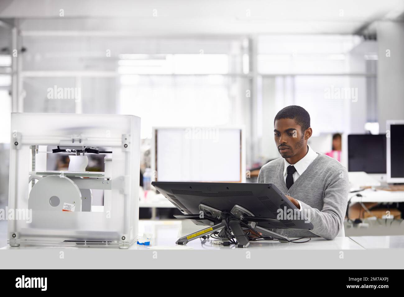 From concept to reality. a young man printing his designs on a 3D ...