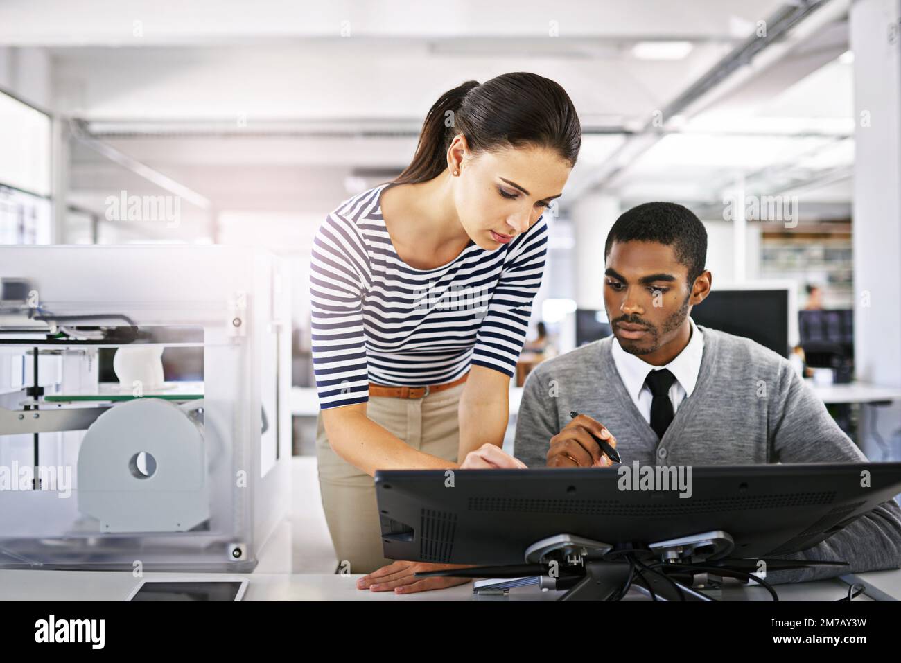 Working on 3d design. two colleagues talking together over a ...