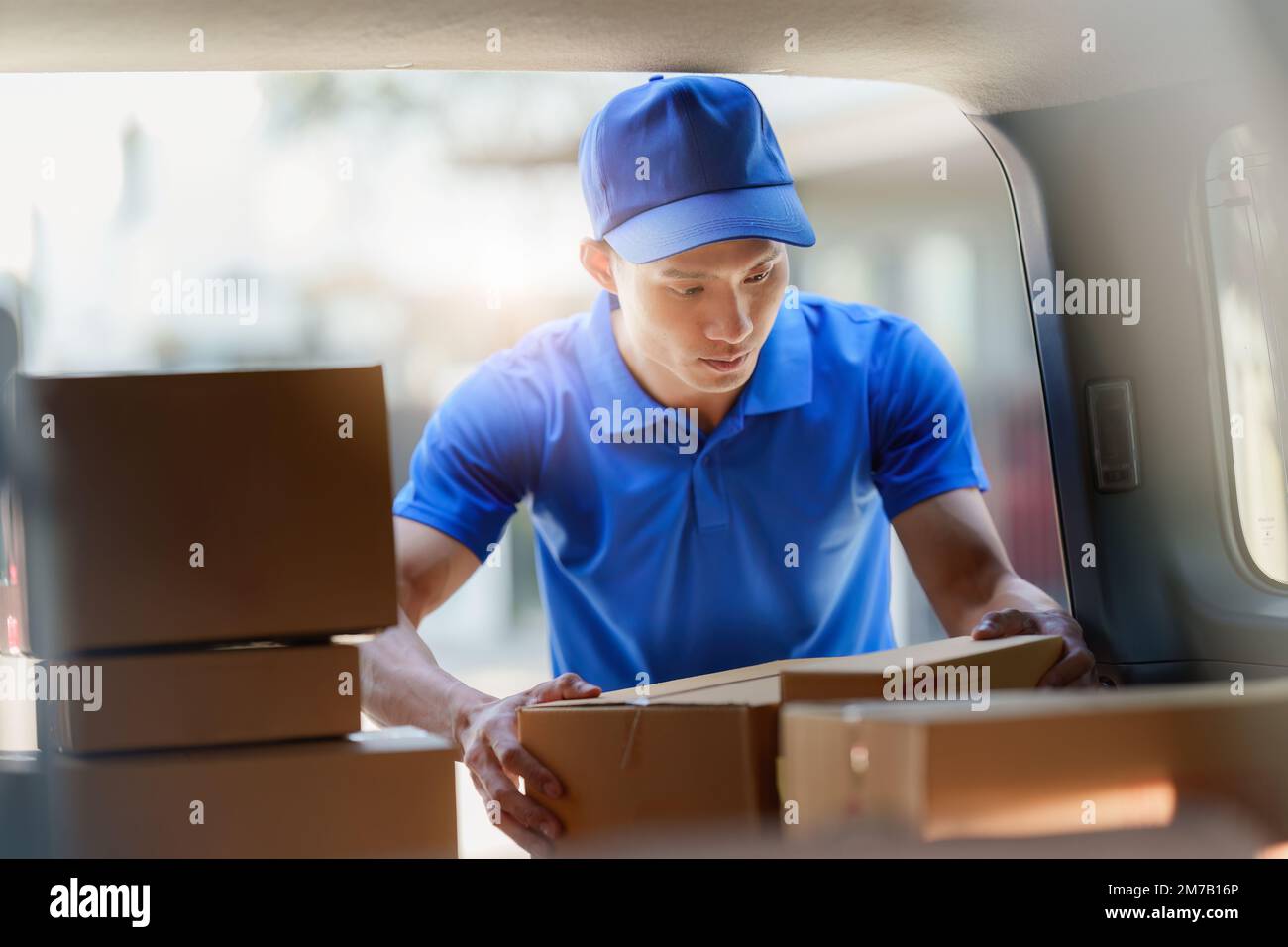 Asian courier with parcel and delivery logistic concept. Delivery man ...