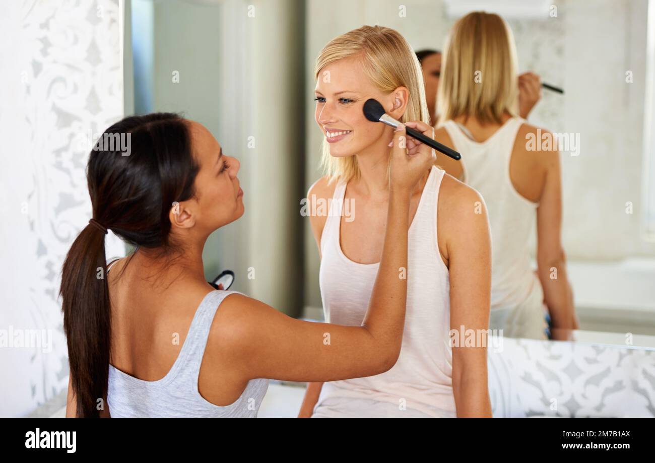 Getting a little help from a friend. a young woman doing her friends ...