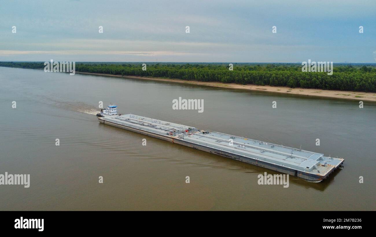 An aerial view of a barge on the Mississippi river with a blue sky in ...