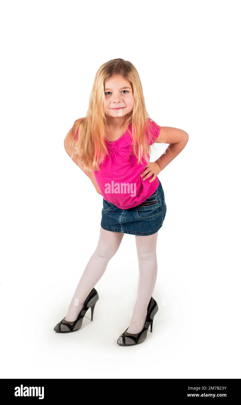 Little girl wearing big high-heeled mother's shoes isolated on white ...