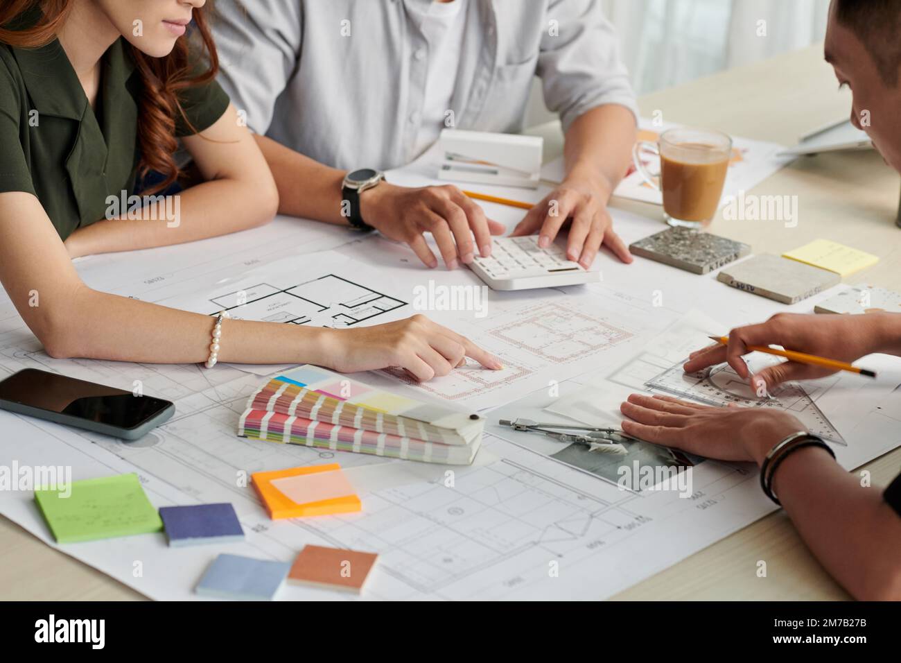Group of architects gathered at big office table to discuss ideas for ...